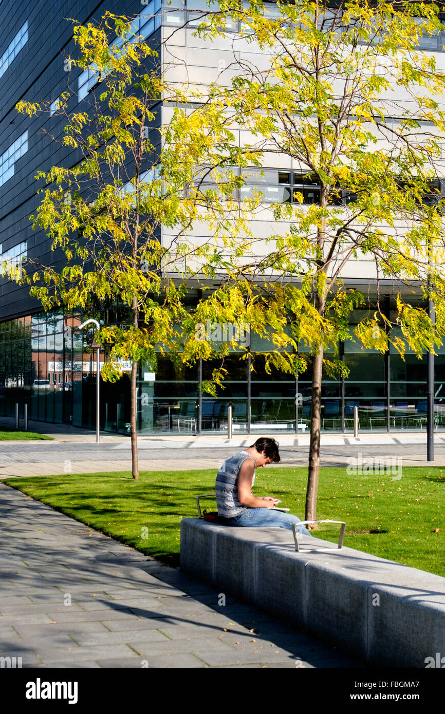 Student sitting on bench and reading outside Alan Turing building, The ...