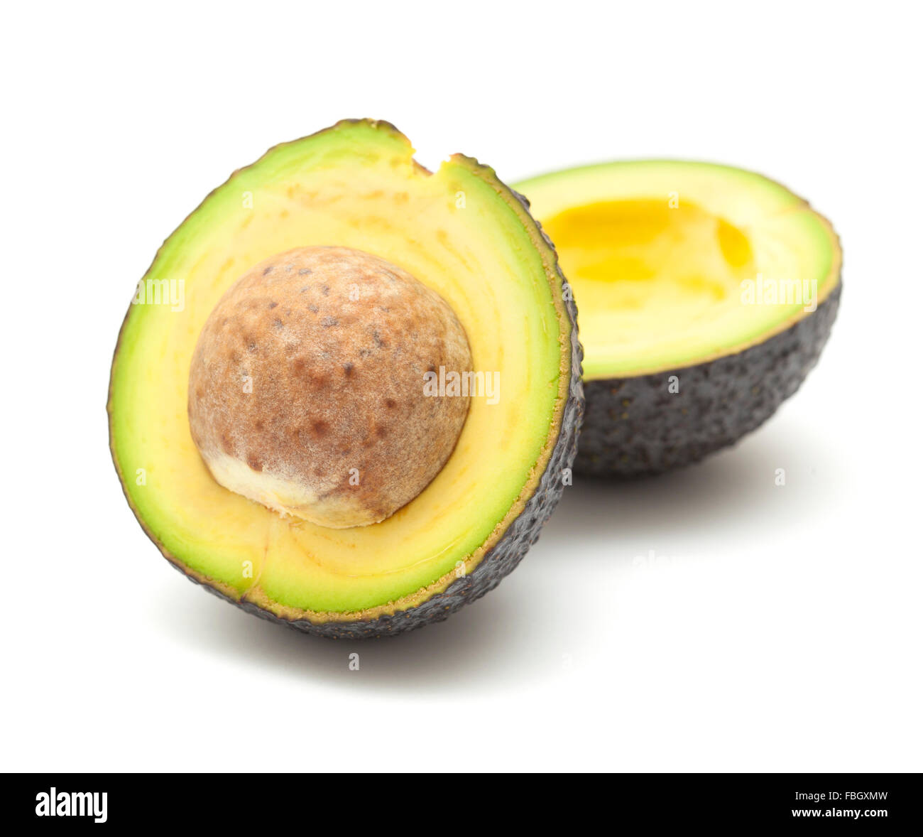 halved round dark skinned avocado pear isolated on white background ...