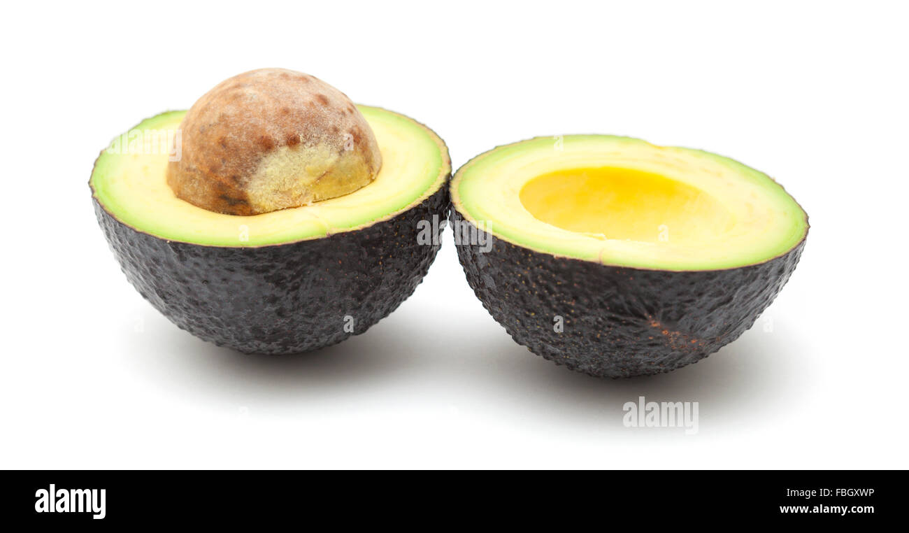 halved round dark skinned avocado pear isolated on white background ...