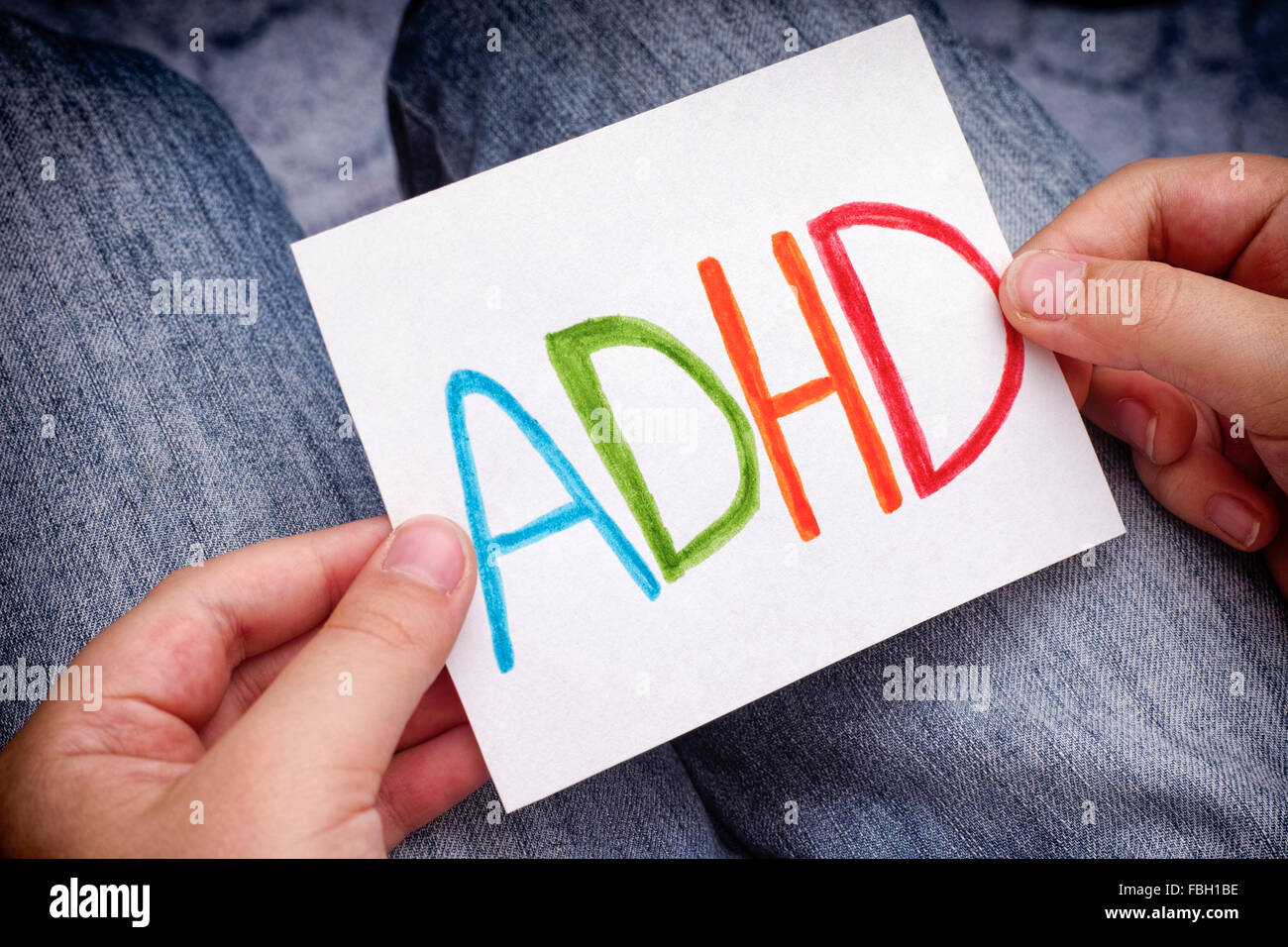 Young boy holds ADHD text written on sheet of paper. ADHD is Attention ...