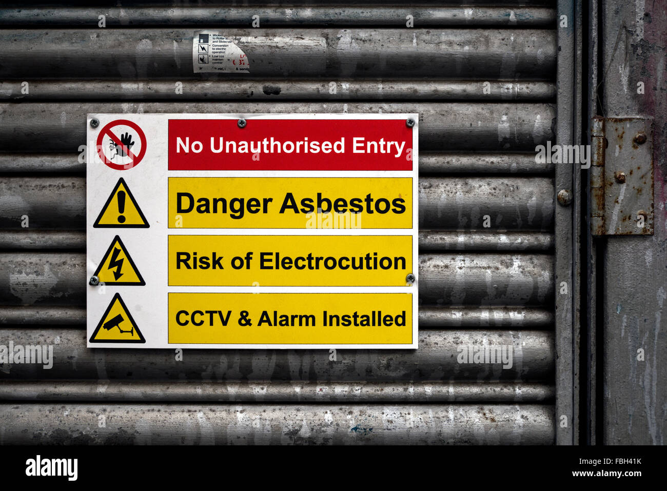 Danger sign attached to the shutters of a derelict building in ...