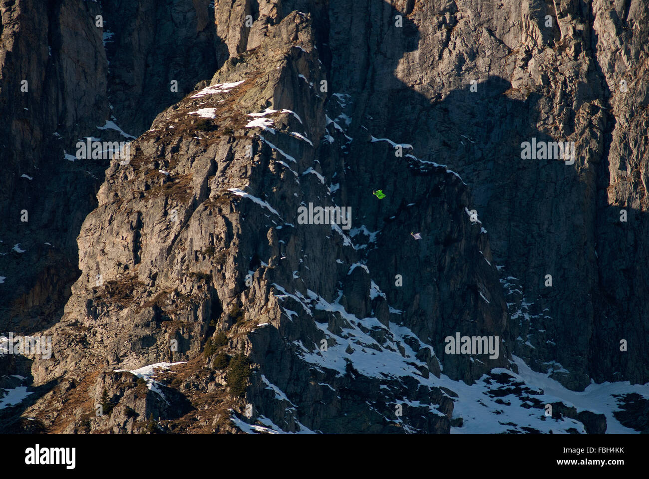 Wingsuit pilot wearing green squirrel suit in flight after launching ...