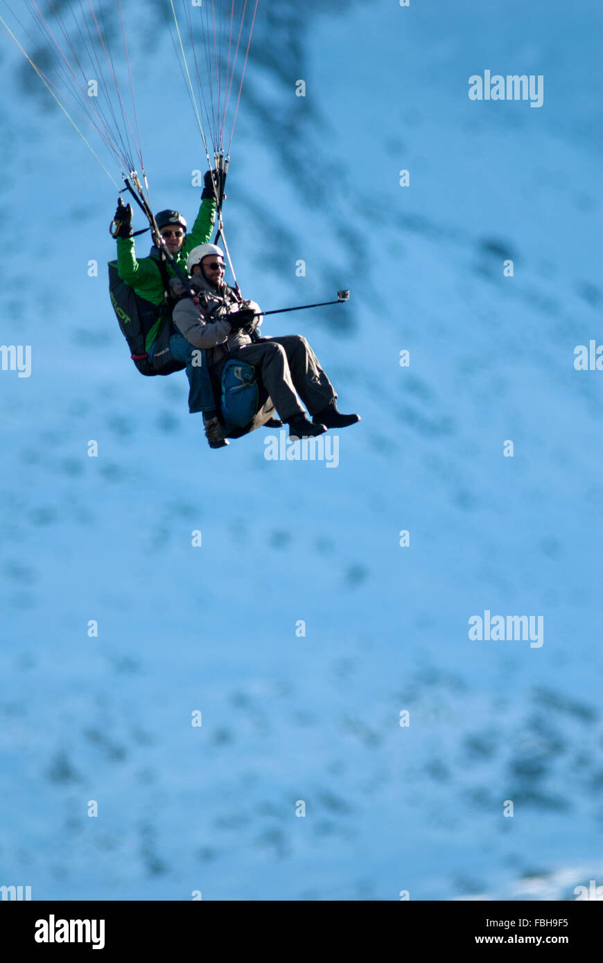 Paraglider pilot with a tandem passenger flying in the Chamonix valley ...