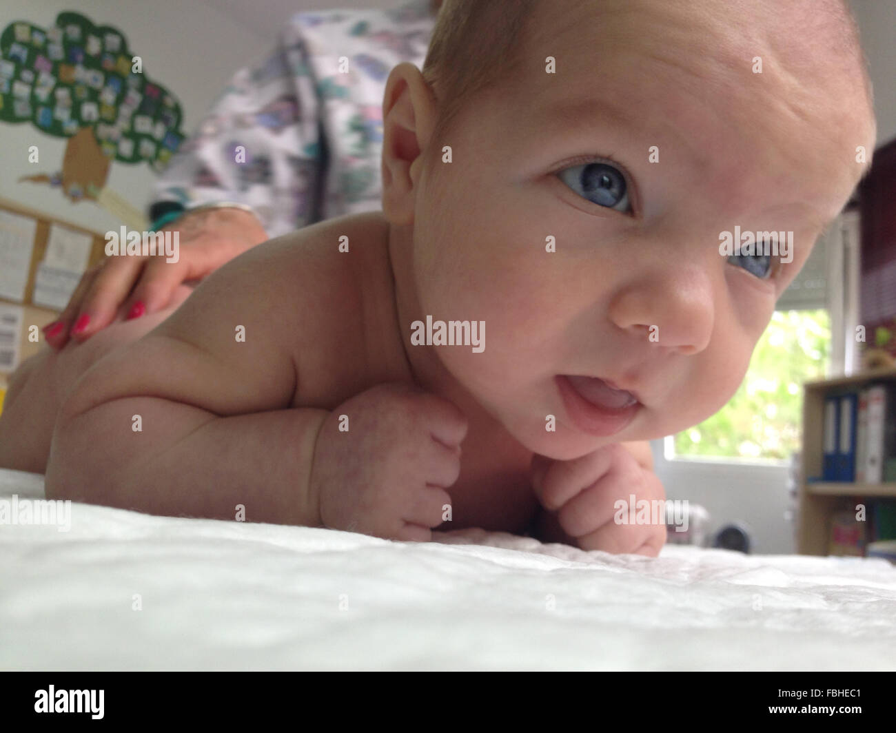 Pediatrician checks out three month baby boy while the boy is over the ...