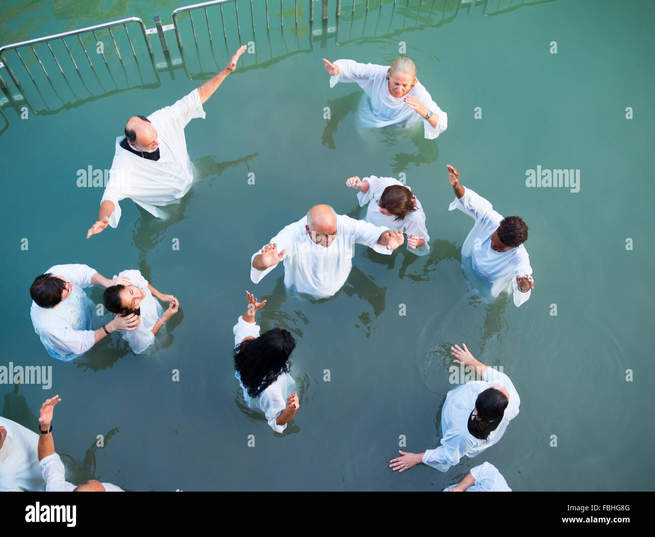 Christian group praying inside the water at the Yardenit baptismal site ...