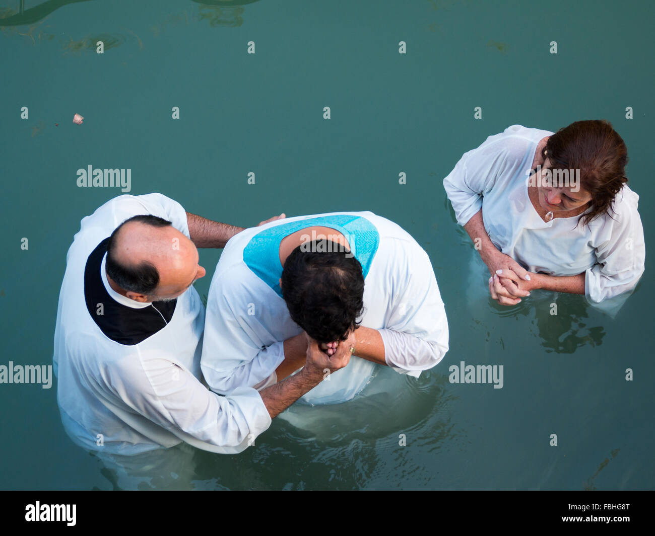 Christian priest baptizing a man in Yardenit baptismal site in Jordan ...