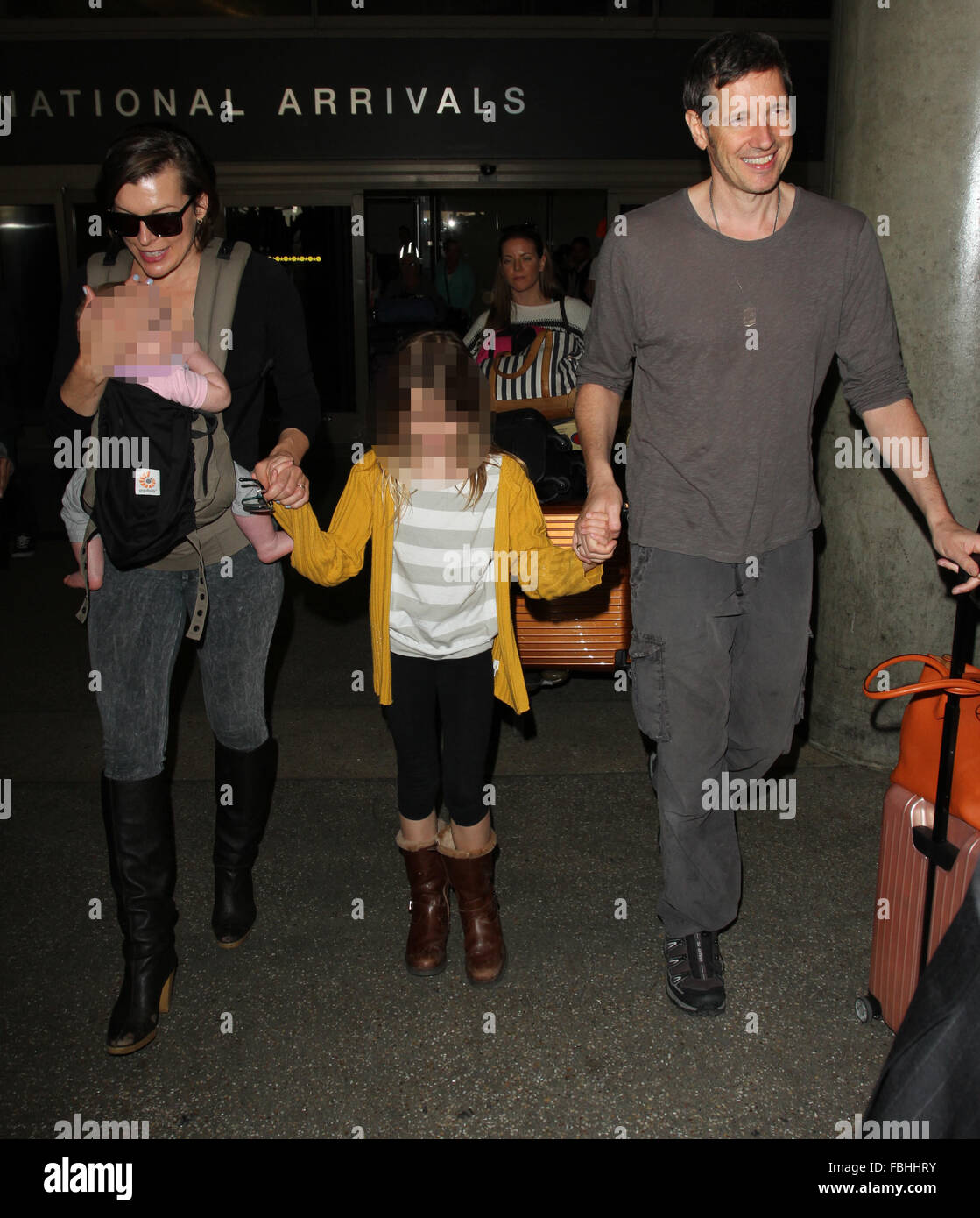 Milla Jovovich and family arrive on a flight to Los Angeles ...