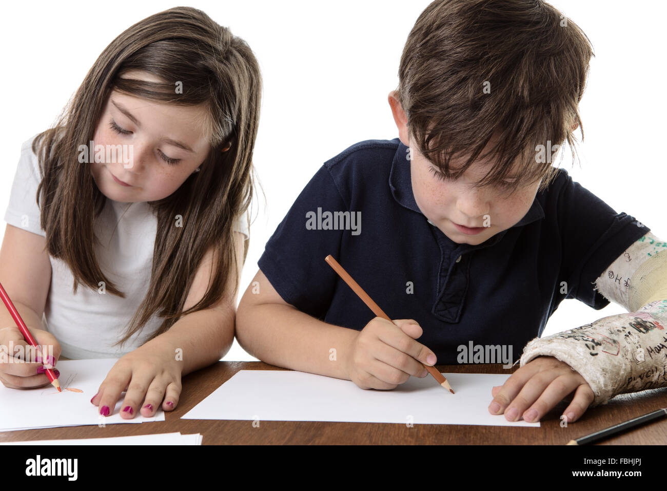 Two children sitting next to each other drawing Stock Photo - Alamy