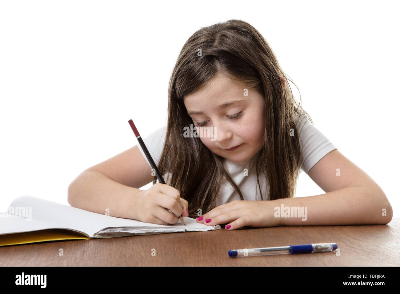Young girl writing in a book doing her homework Stock Photo - Alamy