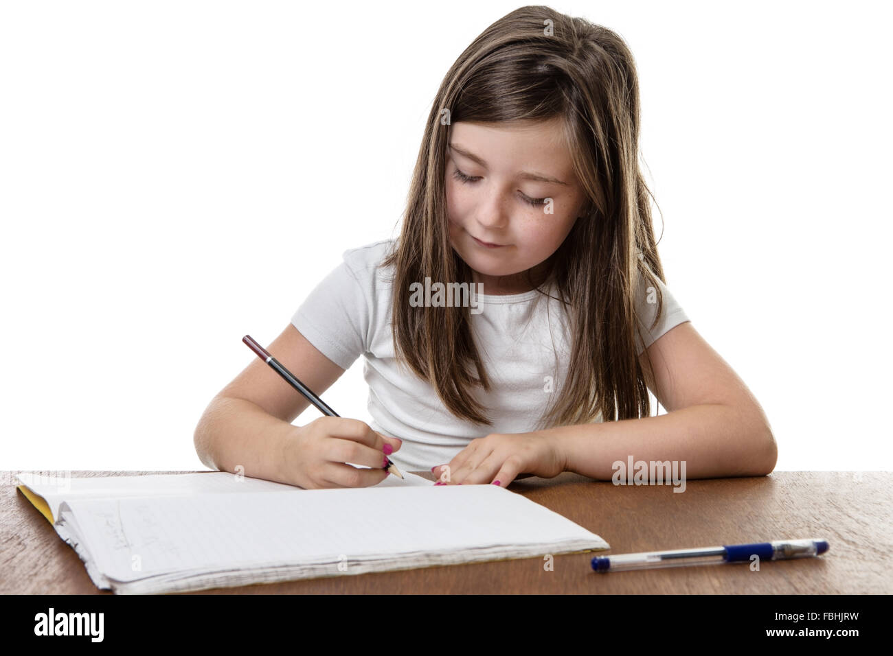 Young girl writing in a book doing her homework Stock Photo - Alamy