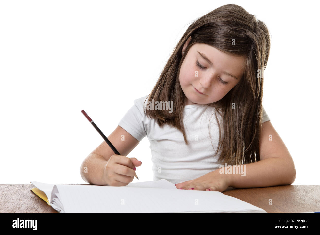 Young girl writing in a book doing her homework Stock Photo - Alamy