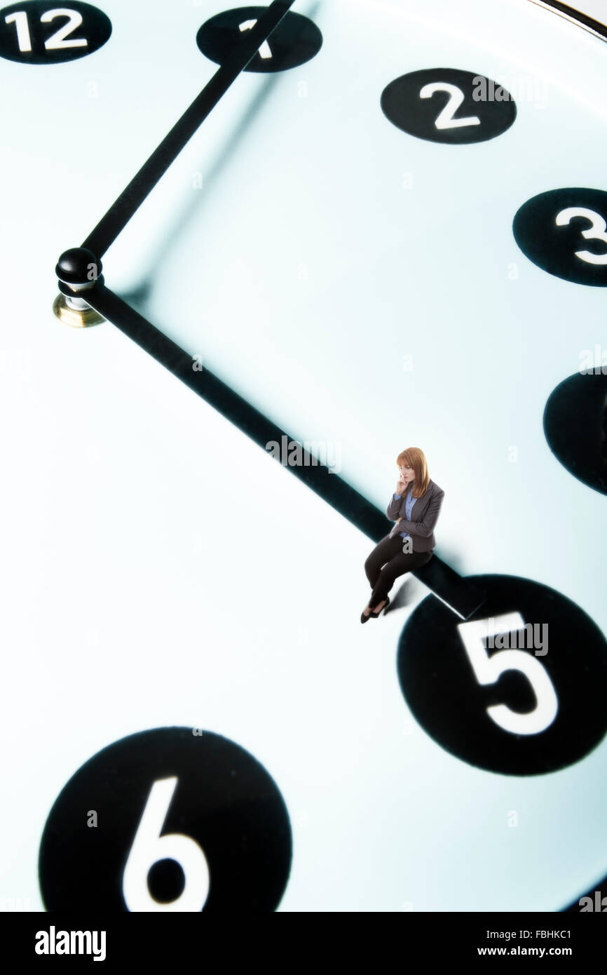 business woman sitting on a clock Stock Photo - Alamy