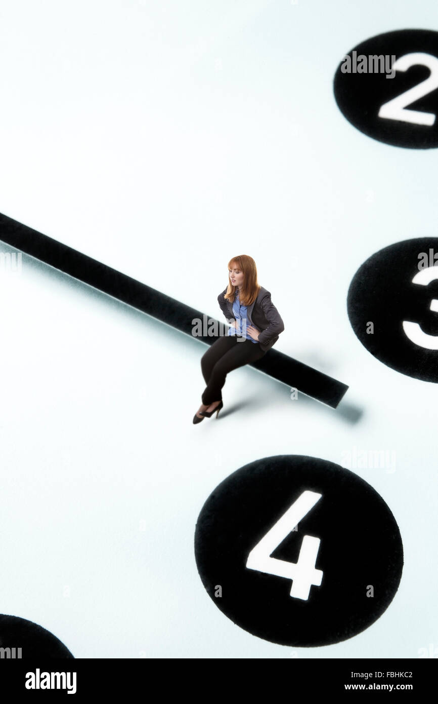 business woman sitting on a clock Stock Photo - Alamy