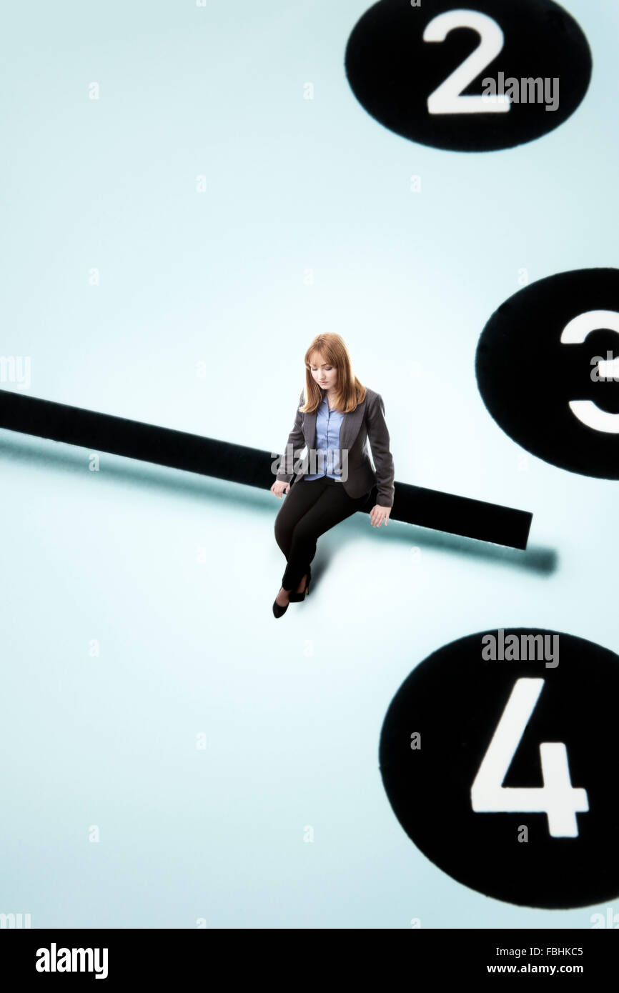 business woman sitting on a clock Stock Photo - Alamy