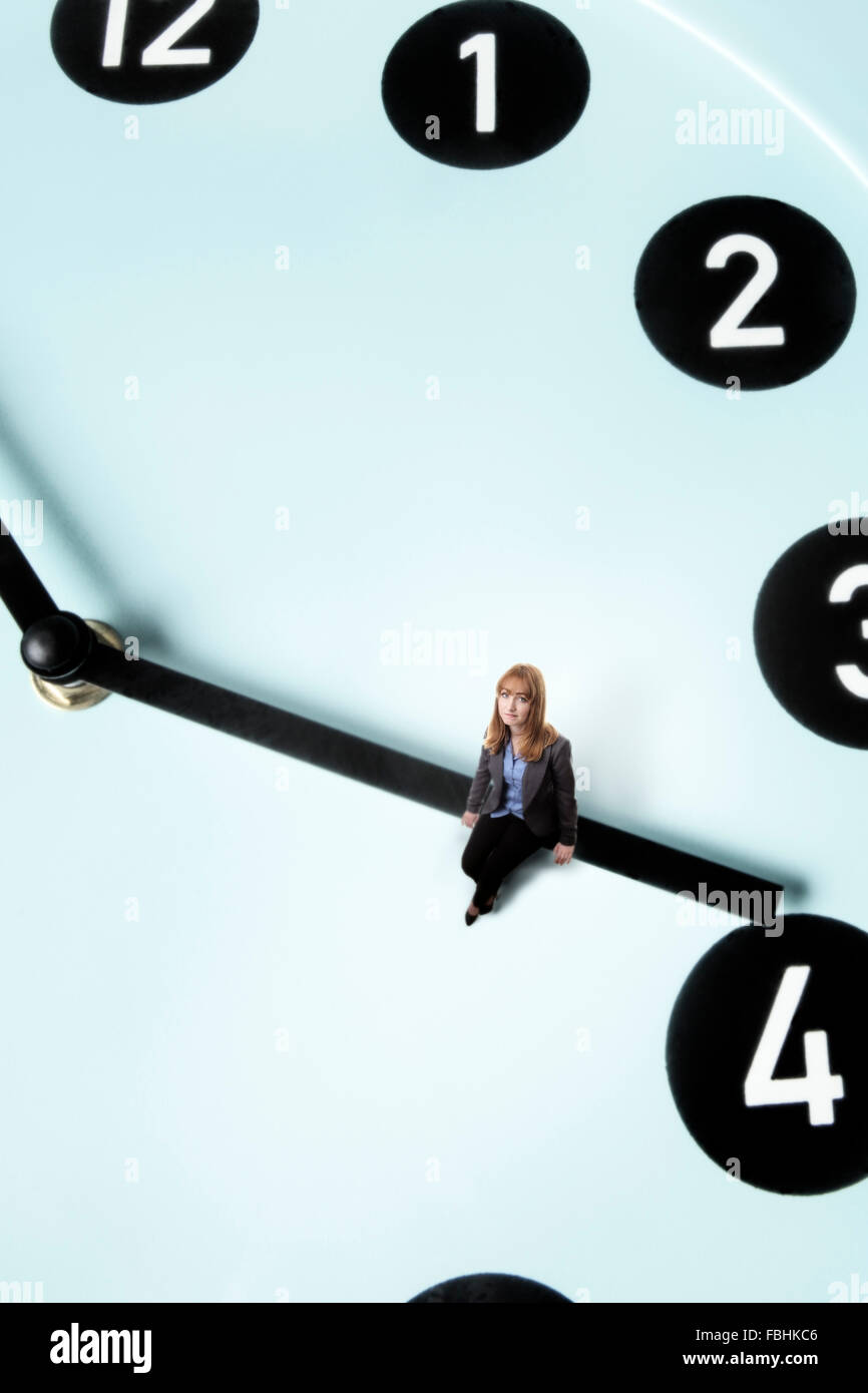 business woman sitting on a clock Stock Photo - Alamy