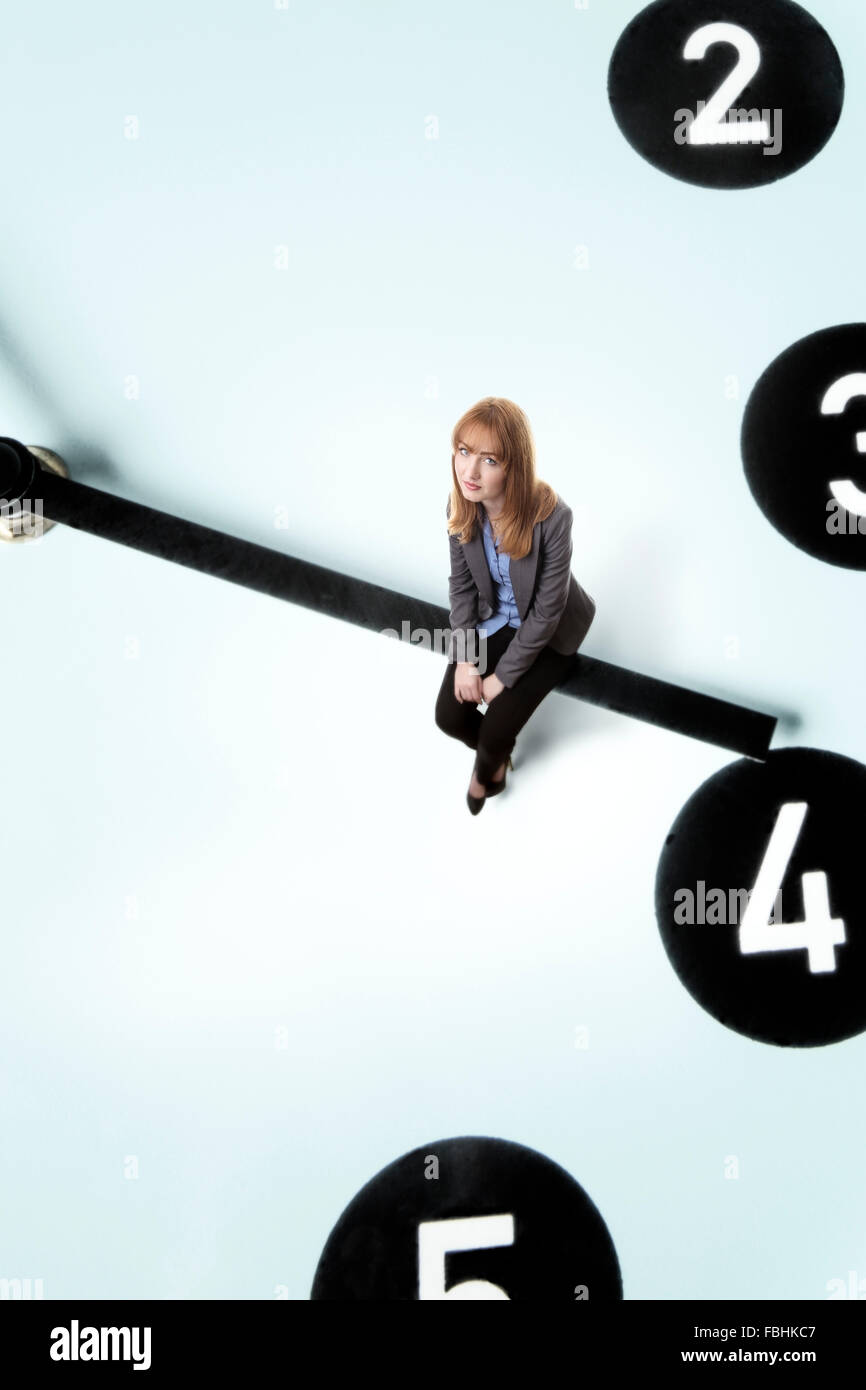 business woman sitting on a clock Stock Photo - Alamy