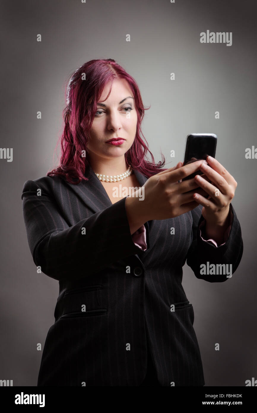 Business woman holding her mobile phone out in her hands and checking ...