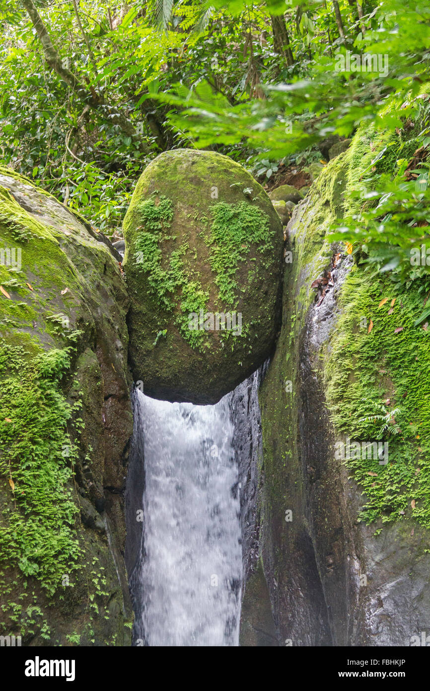 Hanging stone over waterfall Stock Photo - Alamy