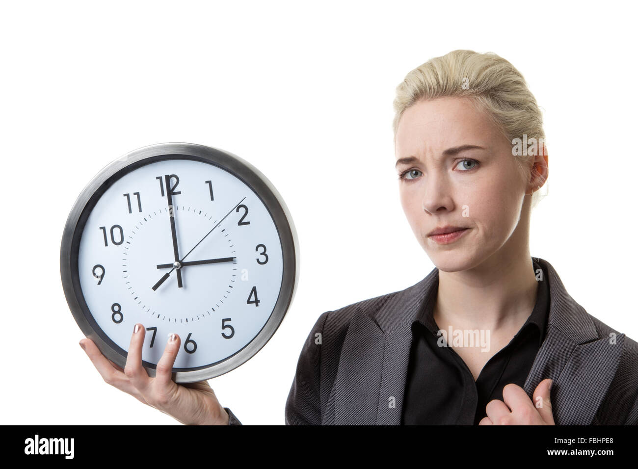 Woman in a suit holding a large clock looking worried Stock Photo - Alamy