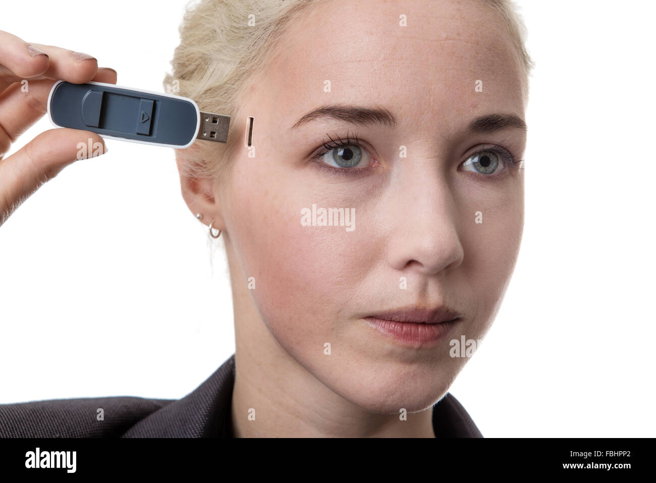 Woman holding a USB memory stick putting it in the side of her head ...