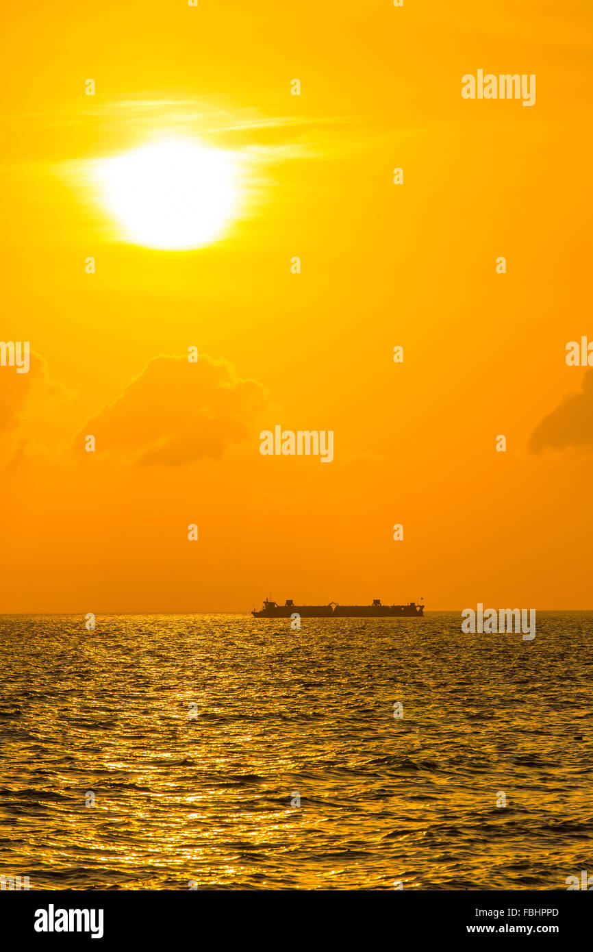 Cargo ship sailing at sunset Stock Photo - Alamy