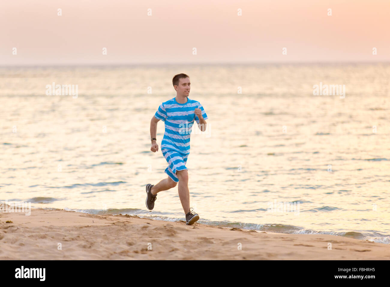 Healthy lifestyle: handsome cheerful young man working out outside ...