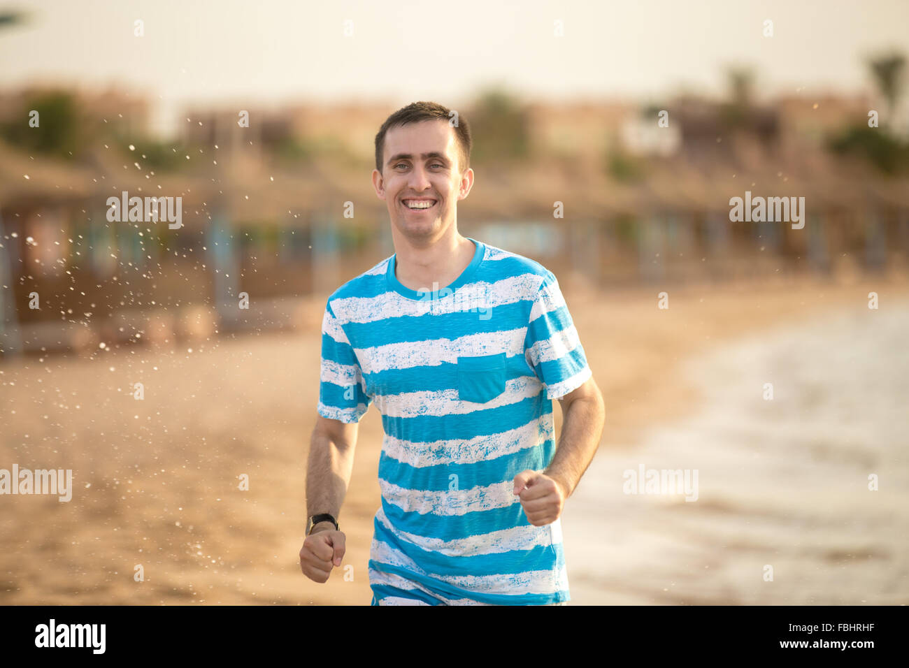Healthy lifestyle: handsome cheerful young man having fun running with ...