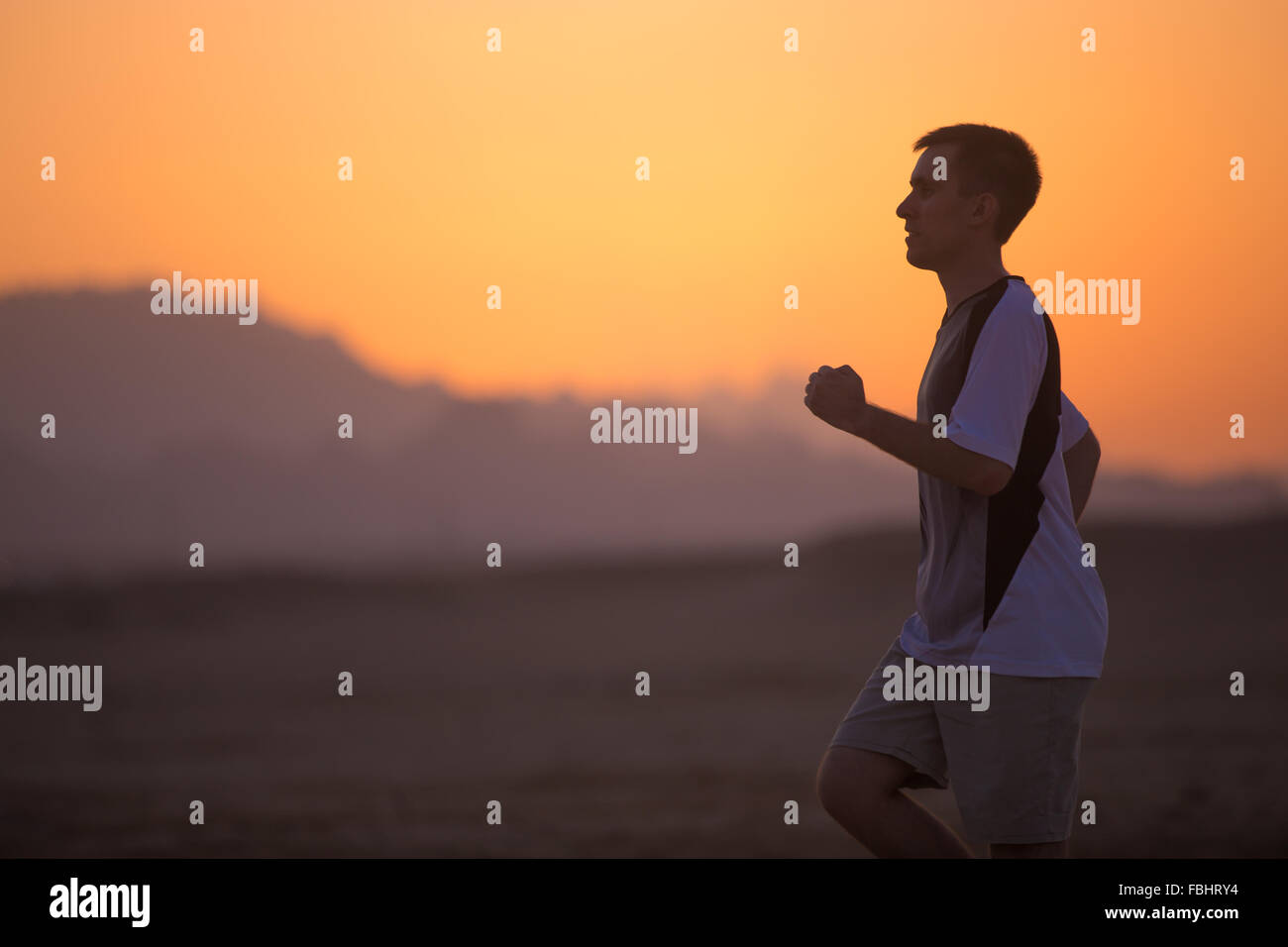 Sporty young man doing running practice on the dusk before sunrise in ...
