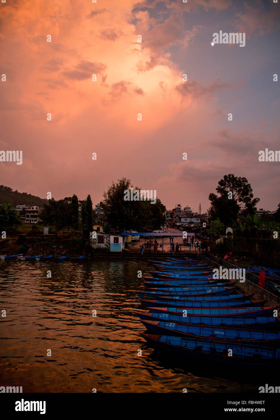Sunset in Pokhara, Nepal Sunset and Moon with blue Boats moored Stock ...