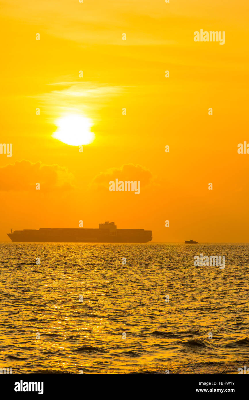 Cargo ship on sea at sunset Stock Photo - Alamy