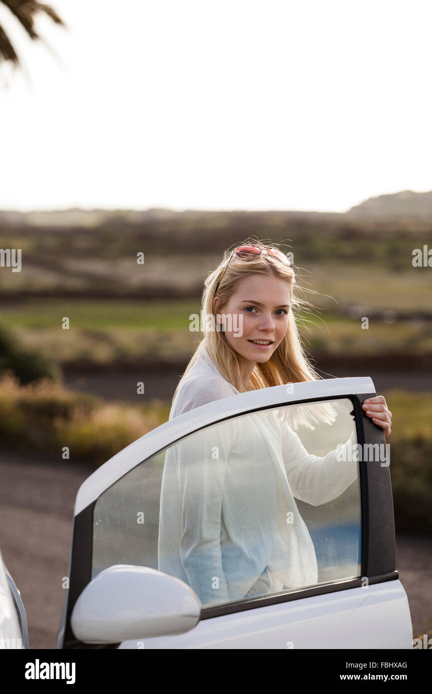 young woman getting out of car Stock Photo - Alamy