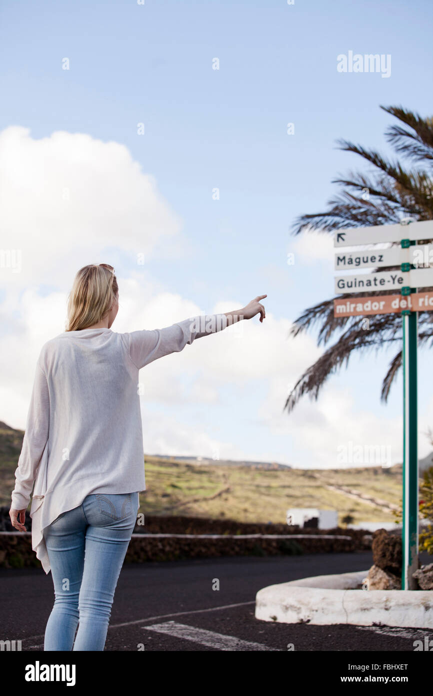 young woman pointing at sign Stock Photo - Alamy