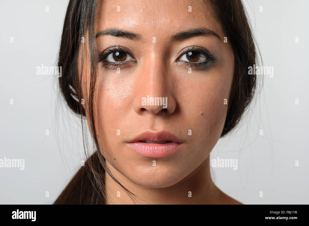 One beautiful young woman with stray hair and serious expression and ...