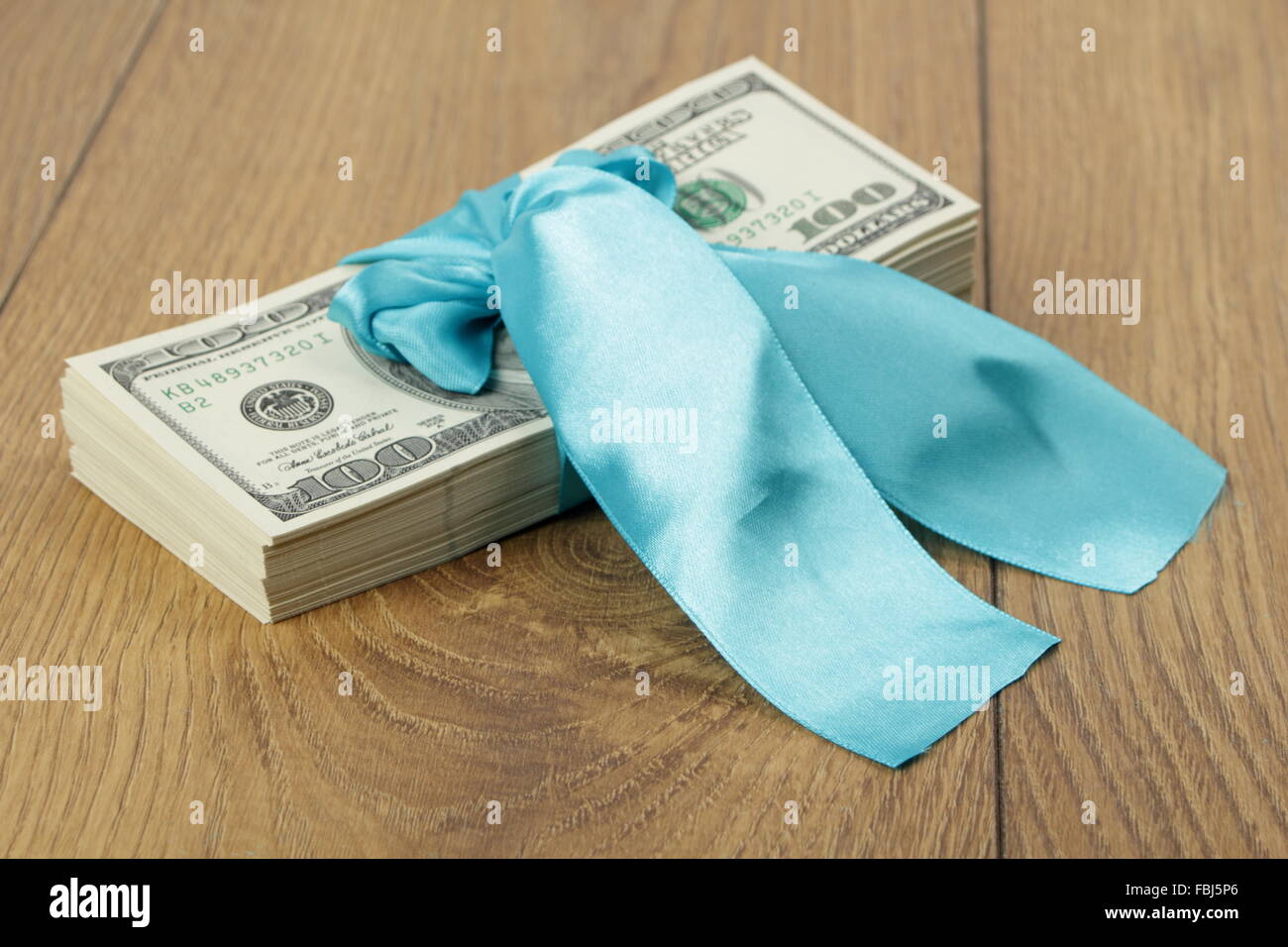 Stack of hundred-dollar bills in a blue gift ribbon Stock Photo - Alamy