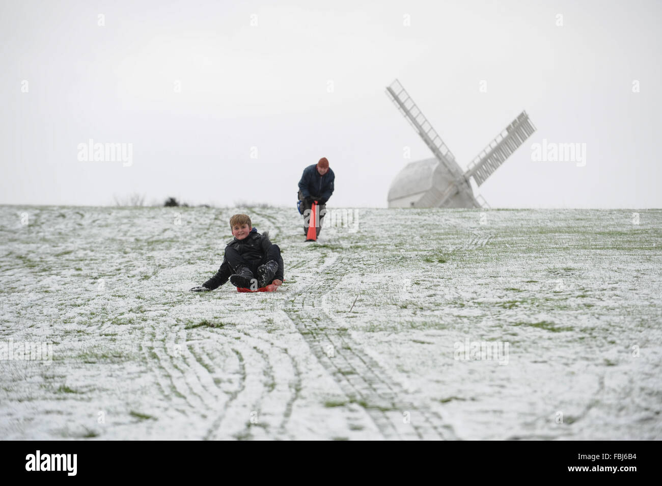 Boy sledging down a snowy hill hi-res stock photography and images - Alamy
