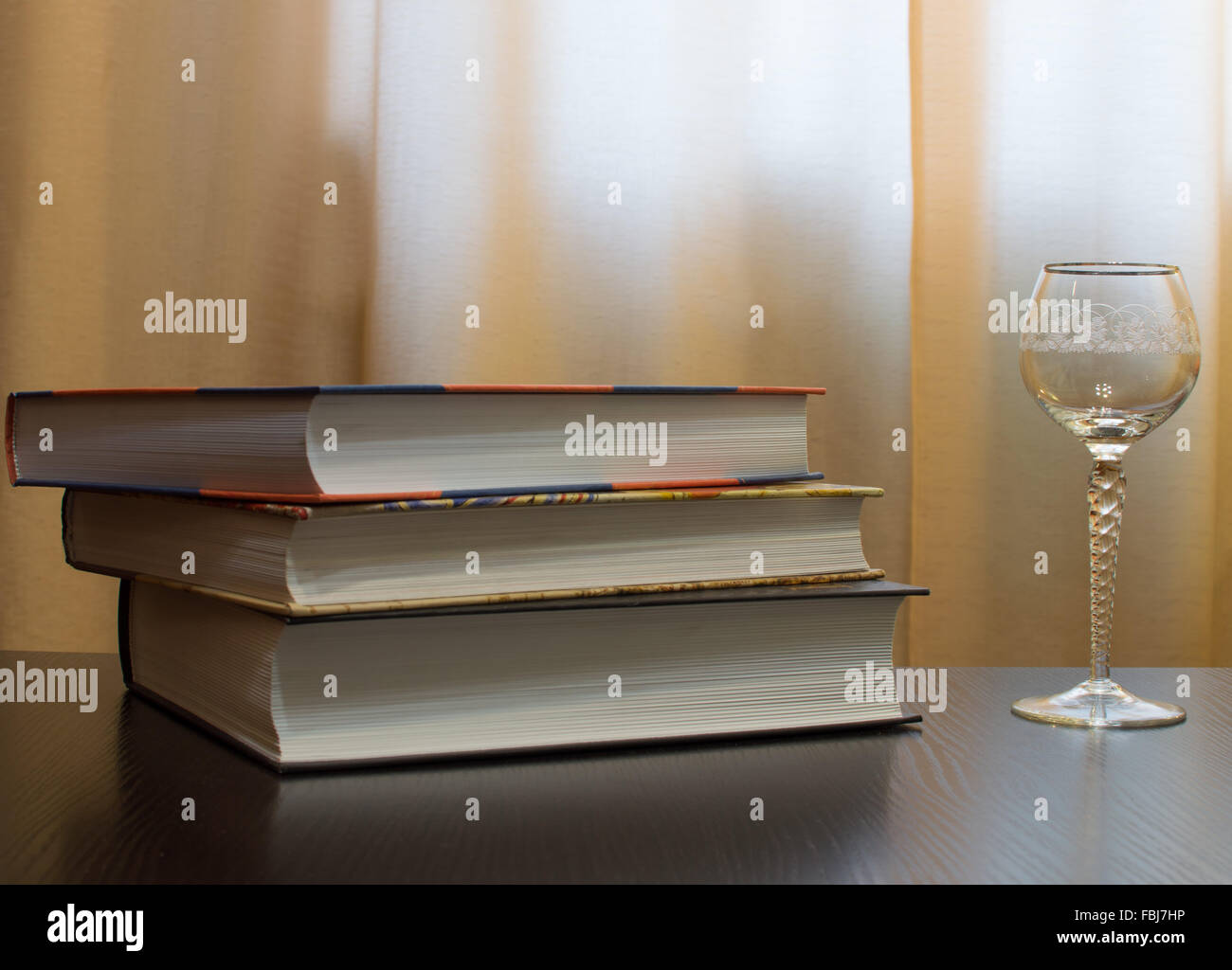 Closed books and empty glass Stock Photo - Alamy