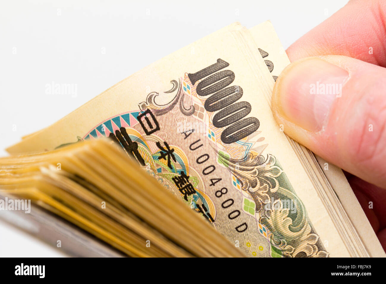 Money, currency. Thumb and finger flicking through wad of Japanese ...