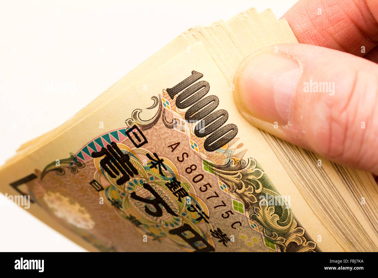 Money, currency. Thumb and finger flicking through wad of Japanese ...