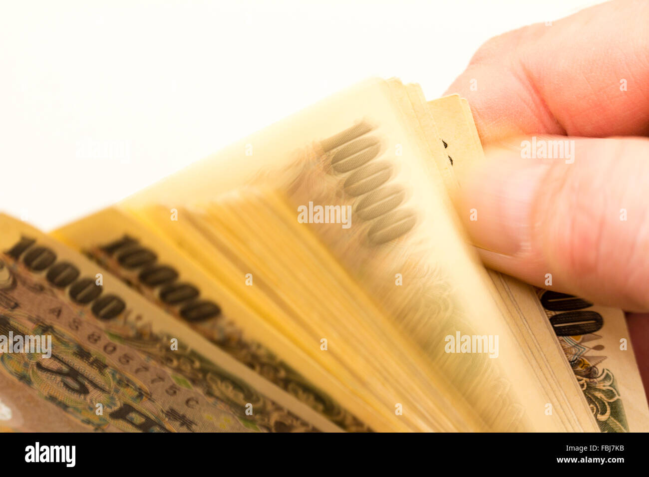 Money, currency. Thumb and finger flicking through wad of Japanese ...