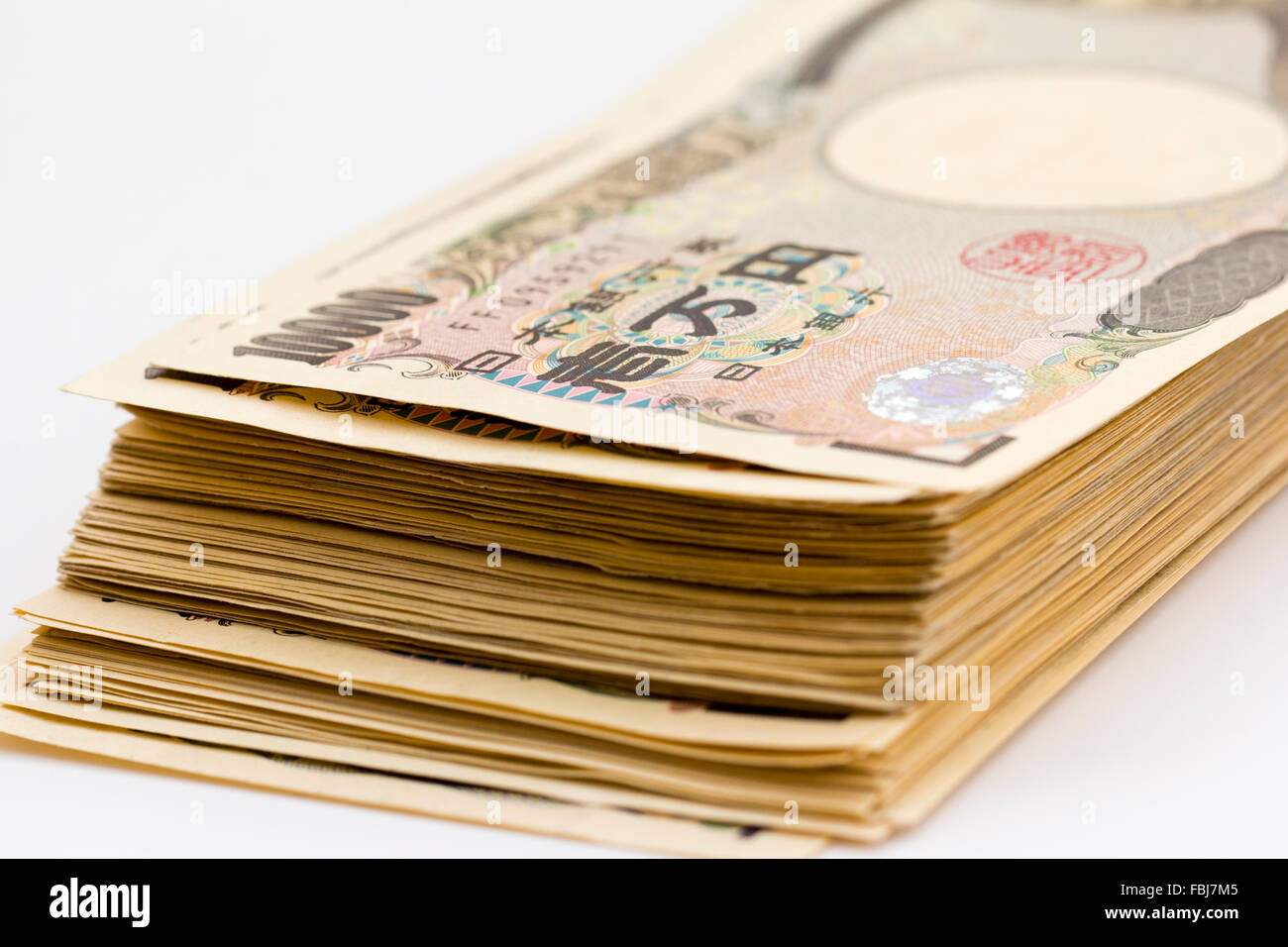 Money, currency. Pile of Japanese banknotes, 10,000 Yen, on plain white ...