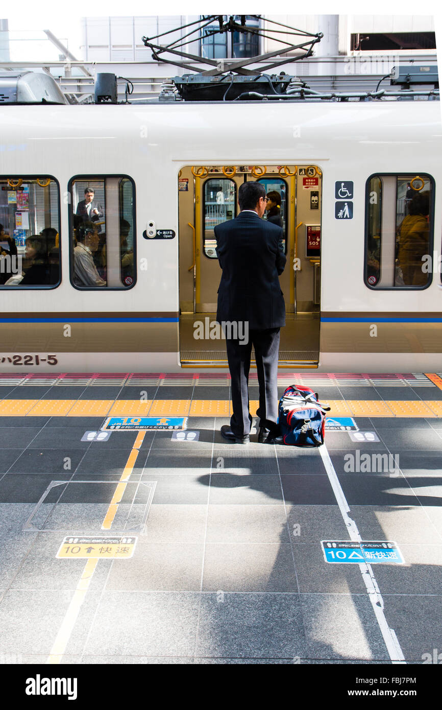Japan, Osaka. Japanese salaryman, business man, waiting for the next ...