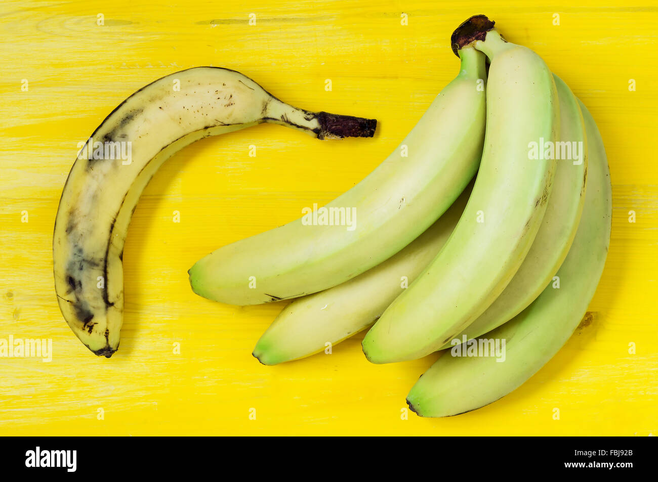 Bananas green branch and one overripe Stock Photo - Alamy