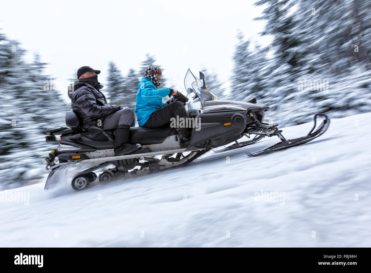 Snowmobile on winter forest road Stock Photo - Alamy