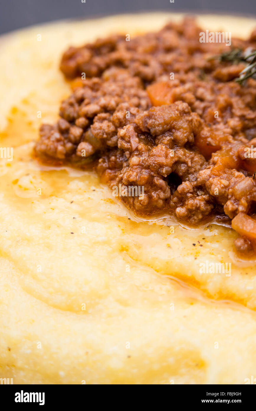 A close up view of a traditional italian dish: Polenta with bolognese ...