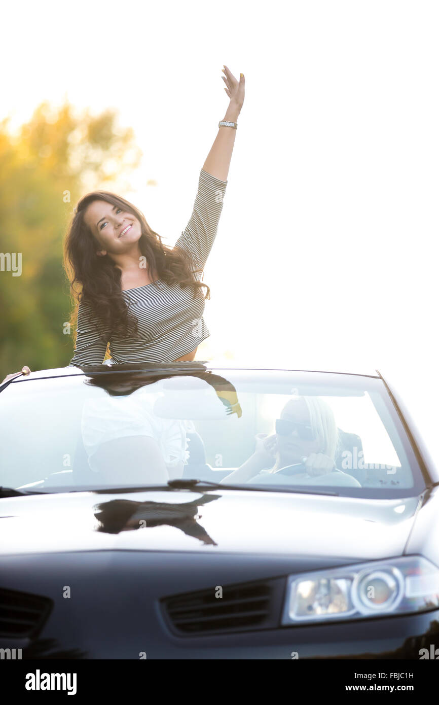 Two happy friends driving modern luxury cabriolet car on vacation on ...