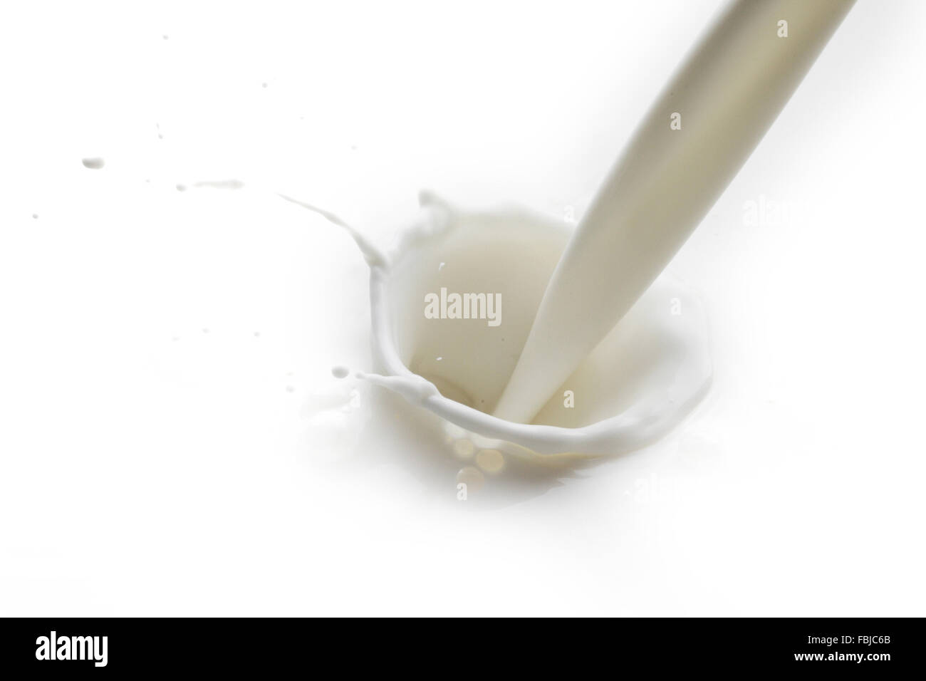 Pouring milk splash isolated on white background macro Stock Photo - Alamy
