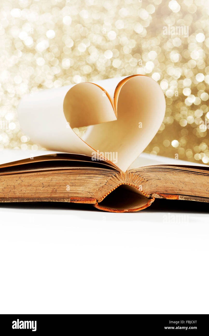 Heart shaped book pages on glitter background Stock Photo - Alamy