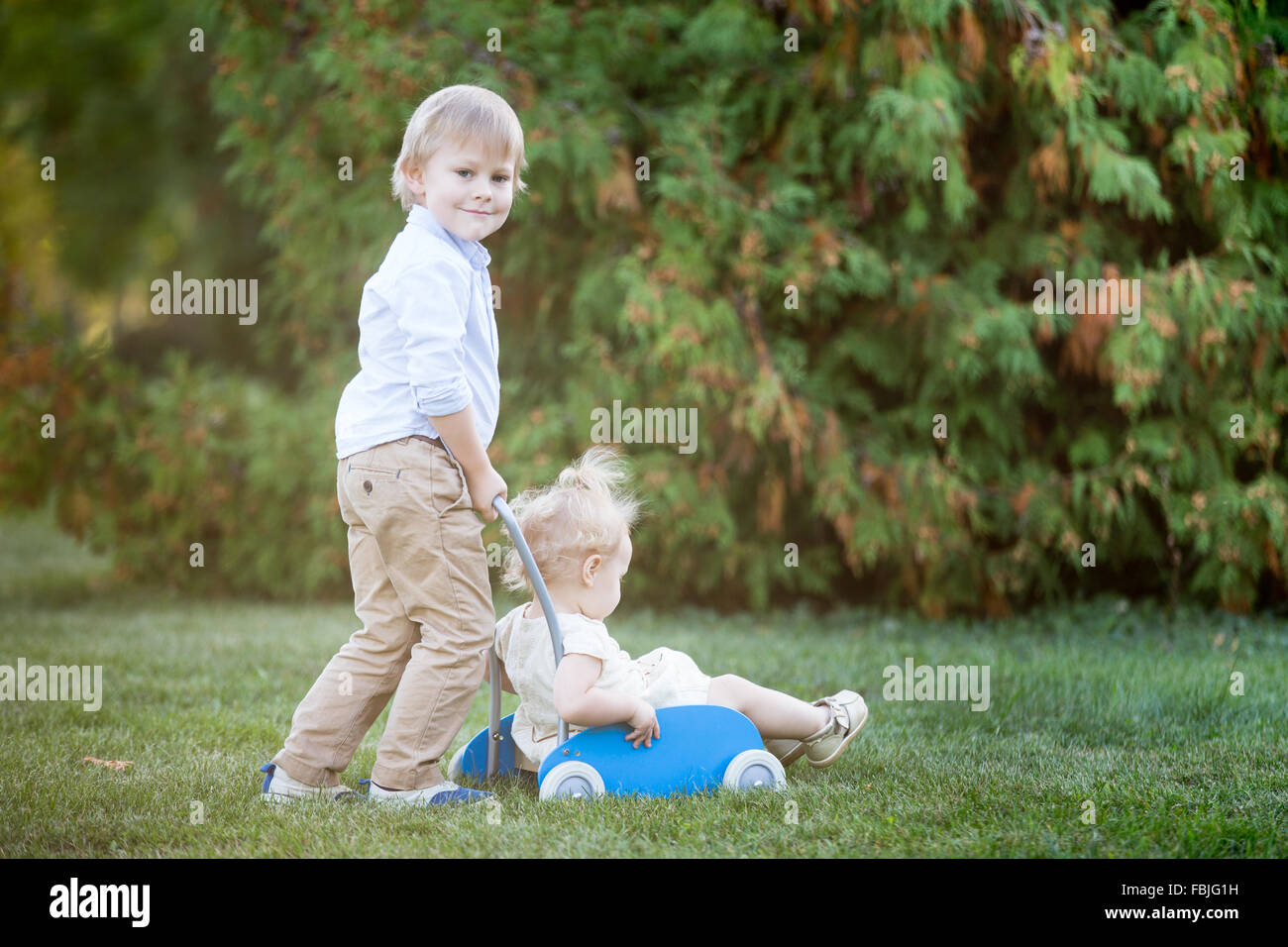 Portrait of two happy cute small siblings playing outside, walking ...