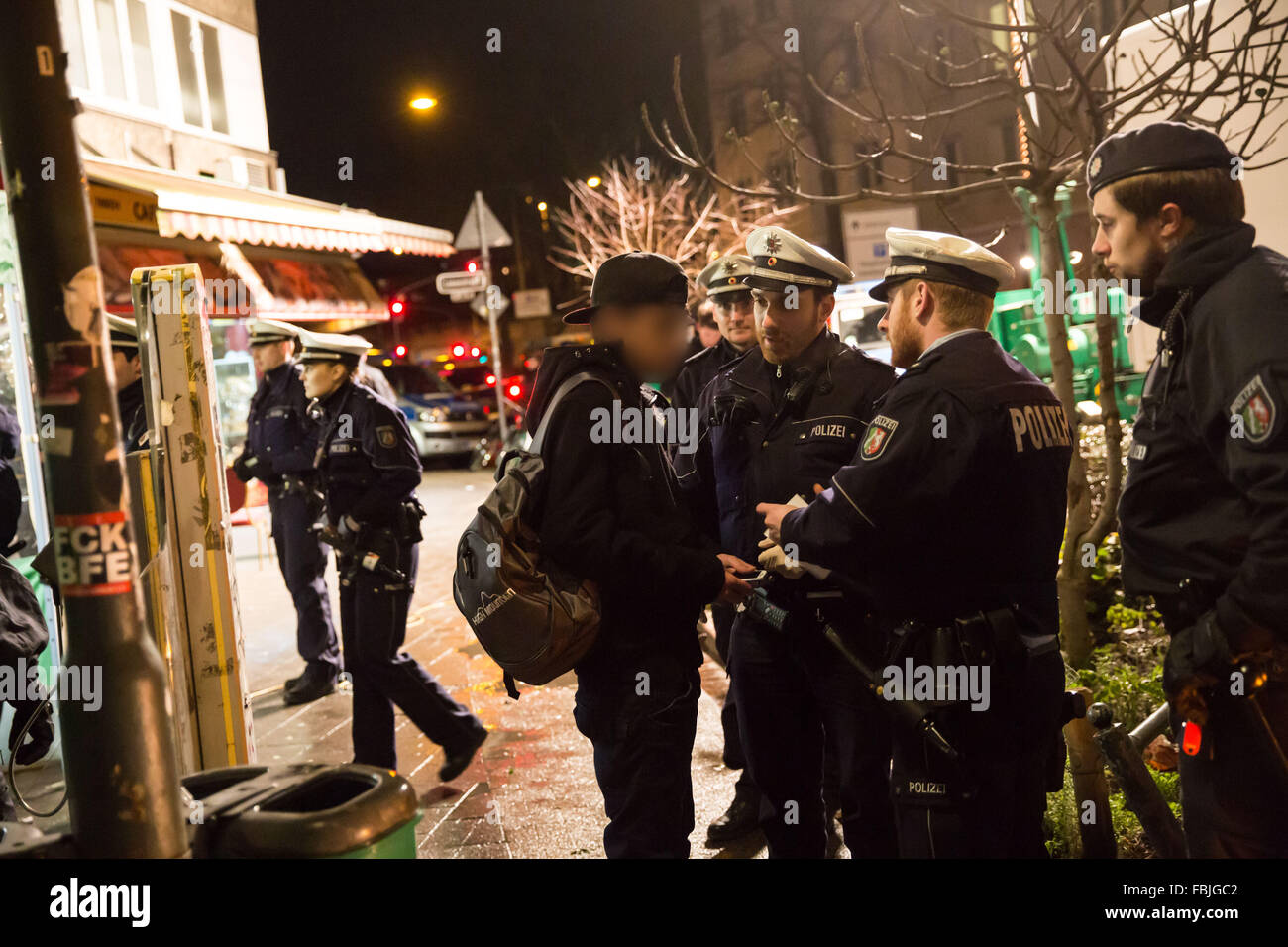 Police stand near a cafe talking to a man during a police roundup in ...