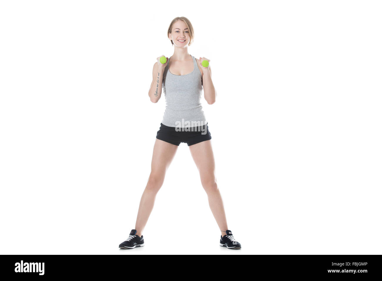 Young happy smiling slim beautiful woman working out, doing exercises ...
